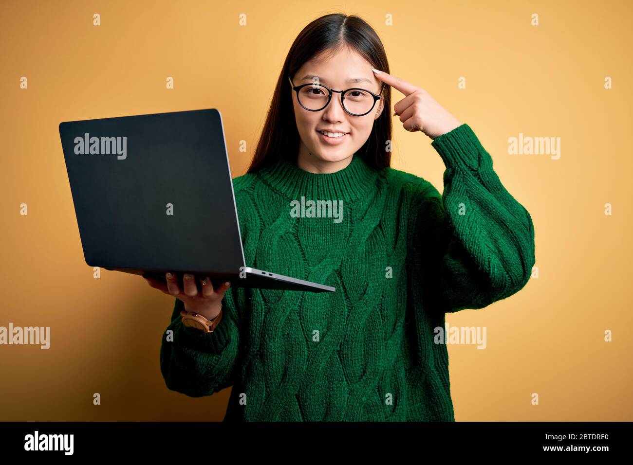 Young asian business woman wearing glasses and working using computer ...