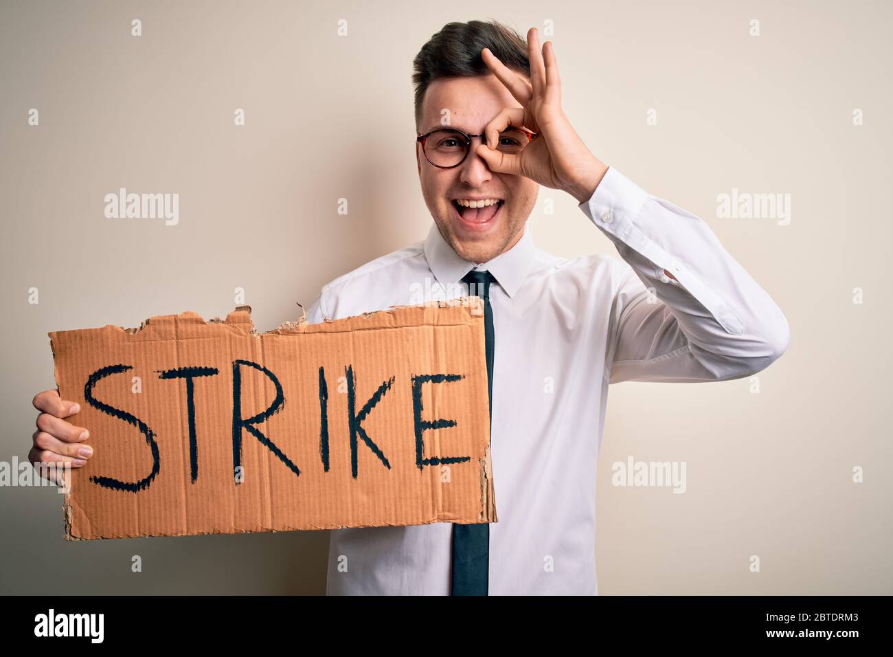 Young handsome caucasian business man holding protest banner on job ...