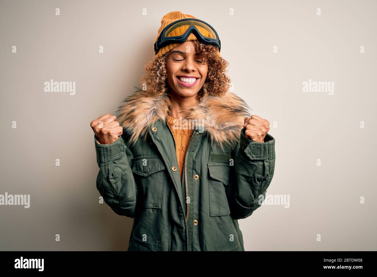 Young african american skier woman with curly hair wearing snow ...