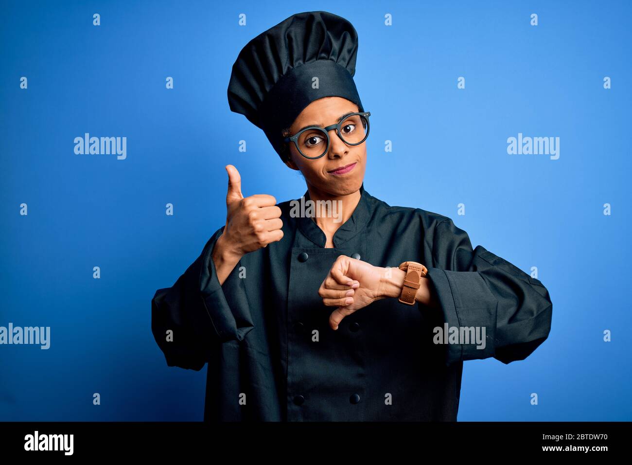 Young african american chef woman wearing cooker uniform and hat over ...