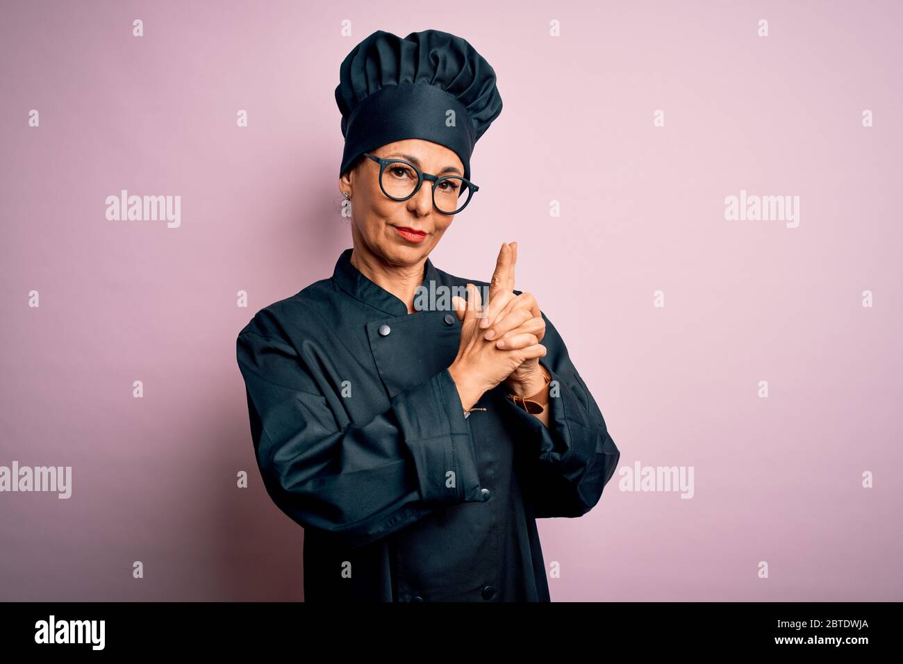 Middle age brunette chef woman wearing cooker uniform and hat over ...