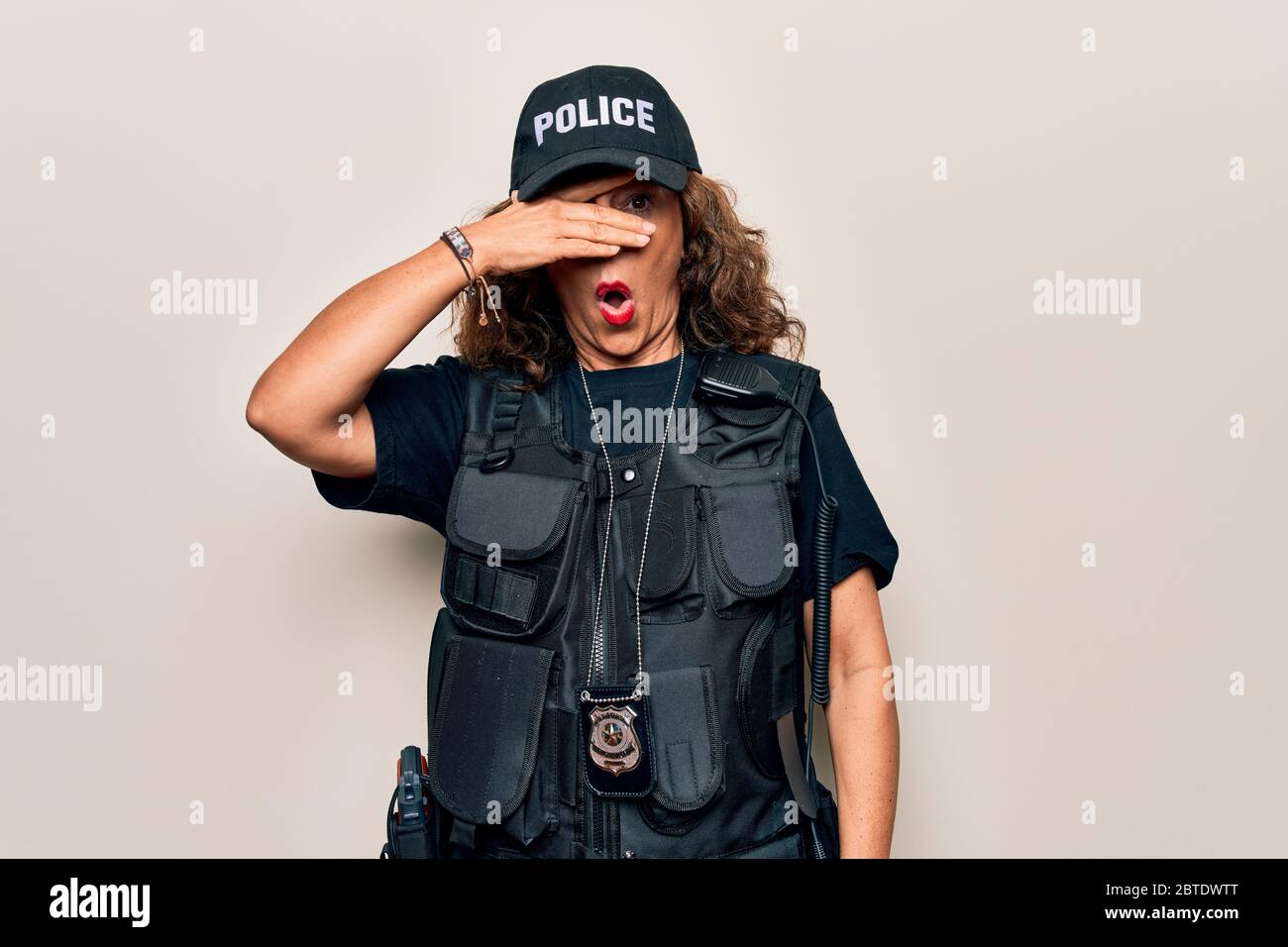 Middle age beautiful policewoman wearing bulletproof uniform and cap ...