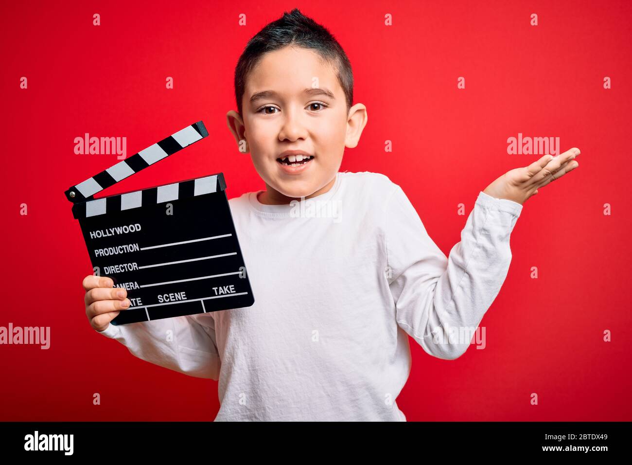 Young little boy kid filming video holding cinema director clapboard ...