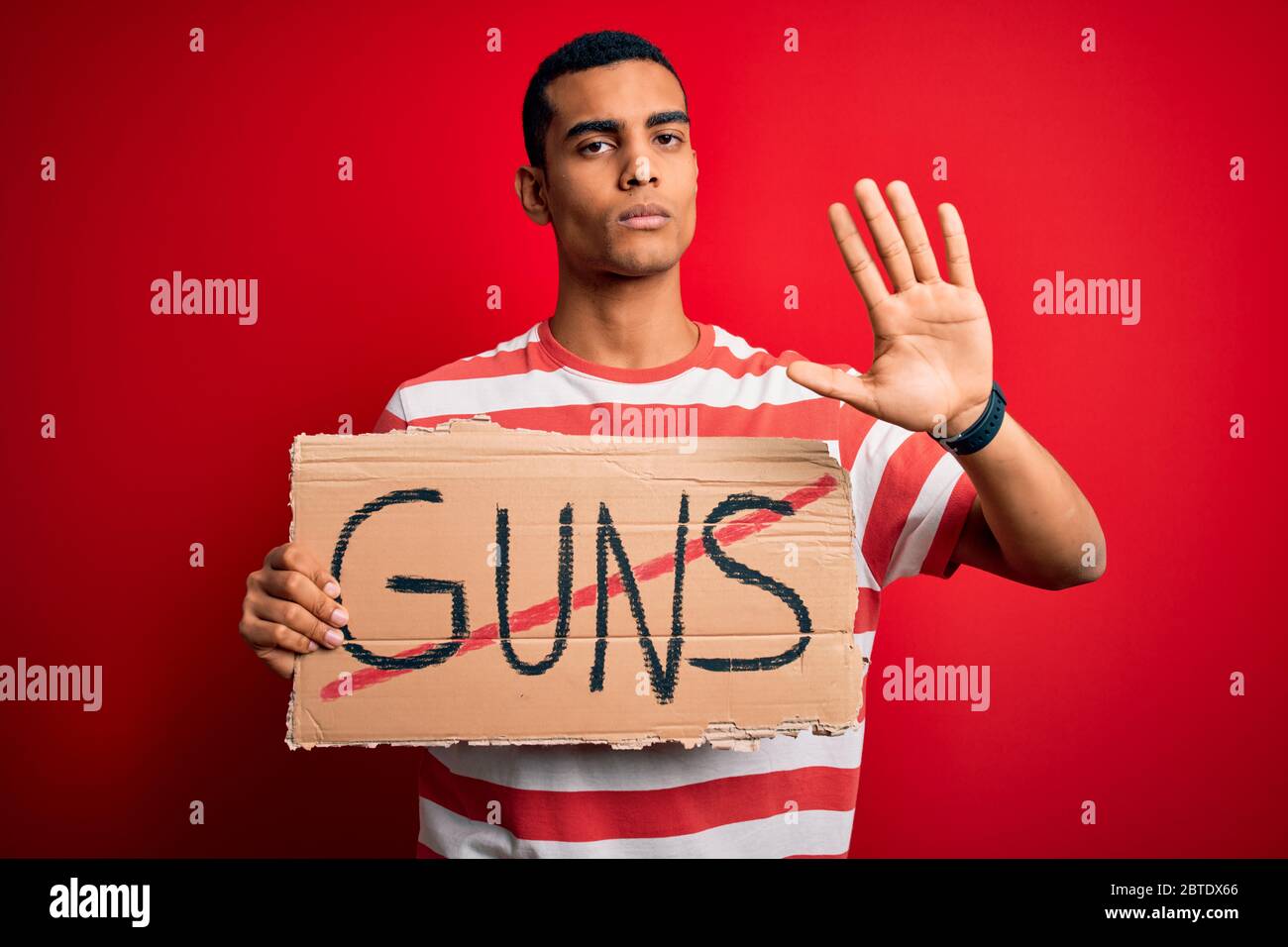 Young handsome african american man holding banner with prohibited guns ...