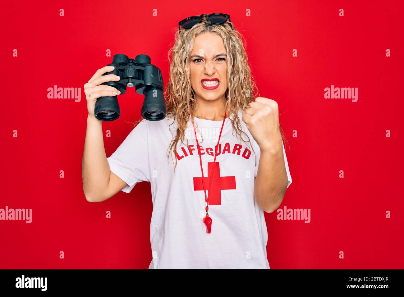 Beautiful blonde lifeguard woman wearing t-shirt with red cross and ...