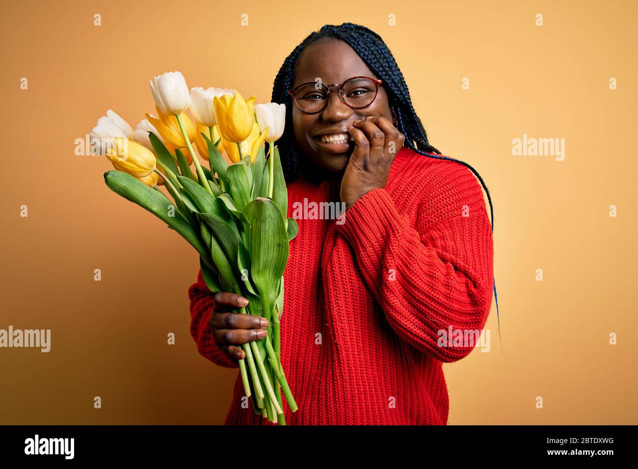 Young african american plus size woman with braids holding bouquet of ...