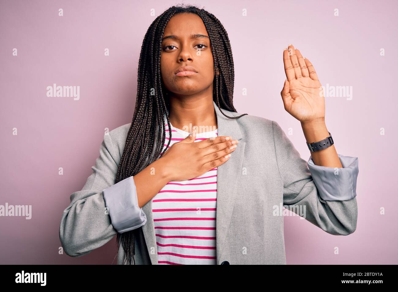 Young african american business woman standing over pink isolated ...