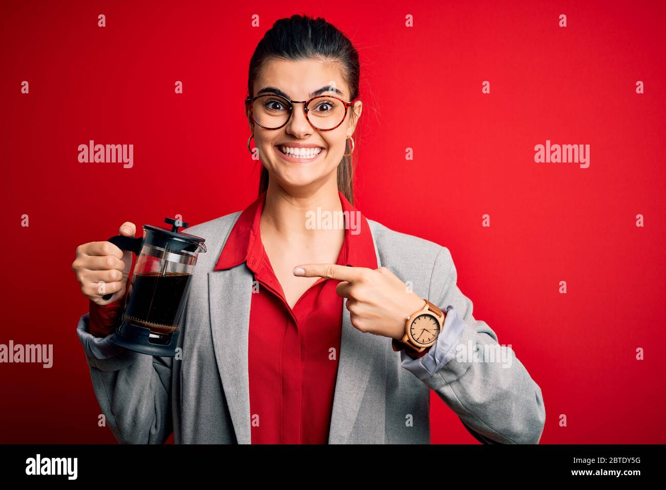 Young beautiful brunette woman doing coffe holding french coffeemaker ...