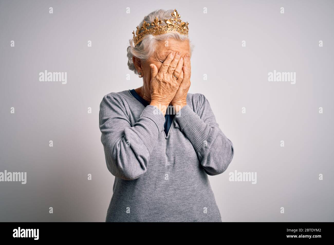 Senior beautiful grey-haired woman wearing golden queen crown over ...