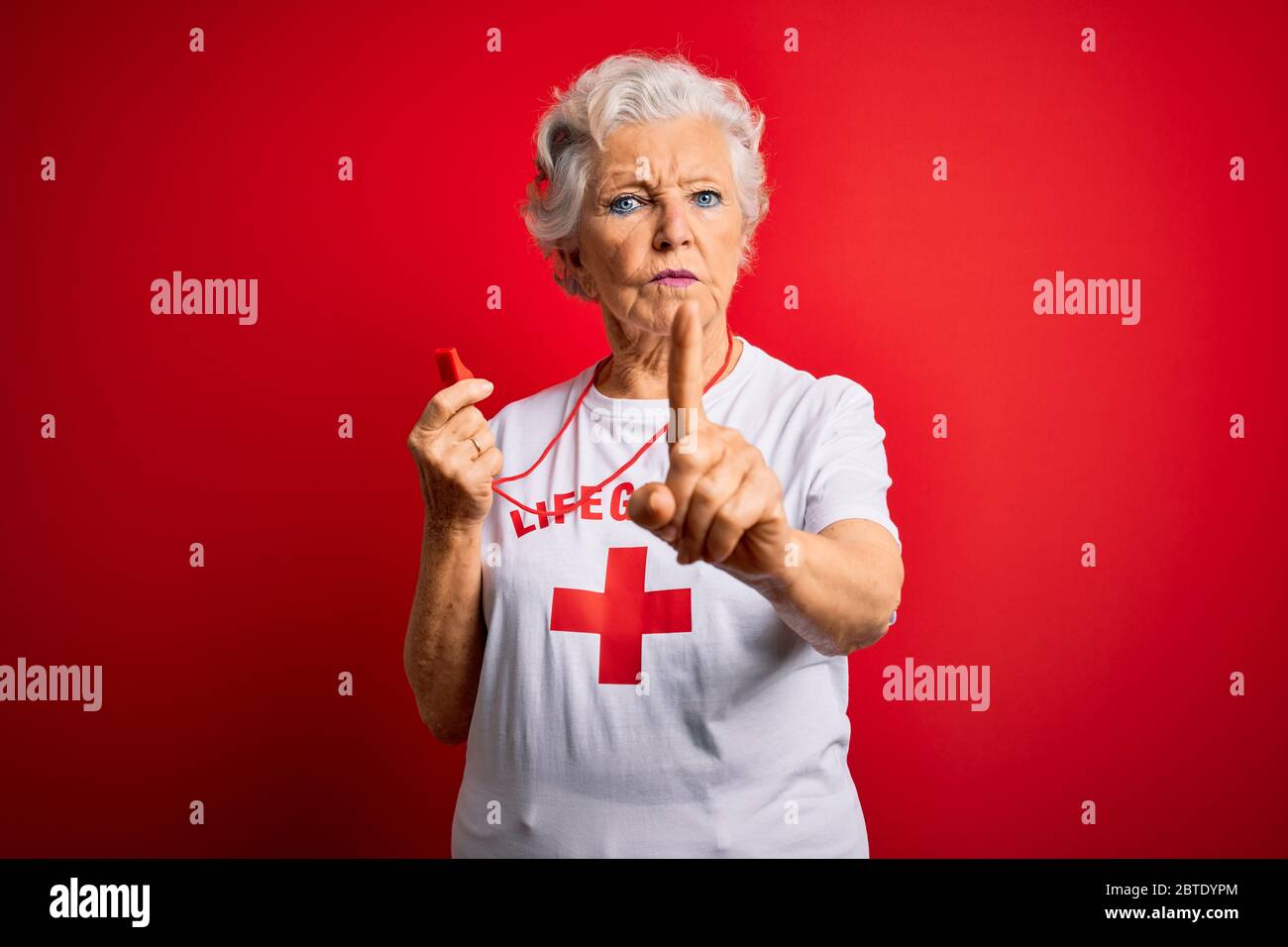 Senior beautiful grey-haired lifeguard woman wearing t-shirt with red ...
