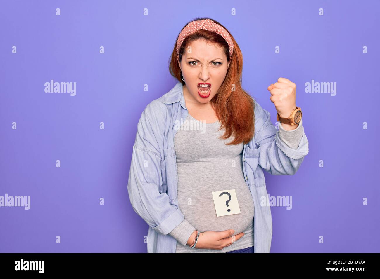 Young beautiful redhead pregnant woman expecting baby with question ...