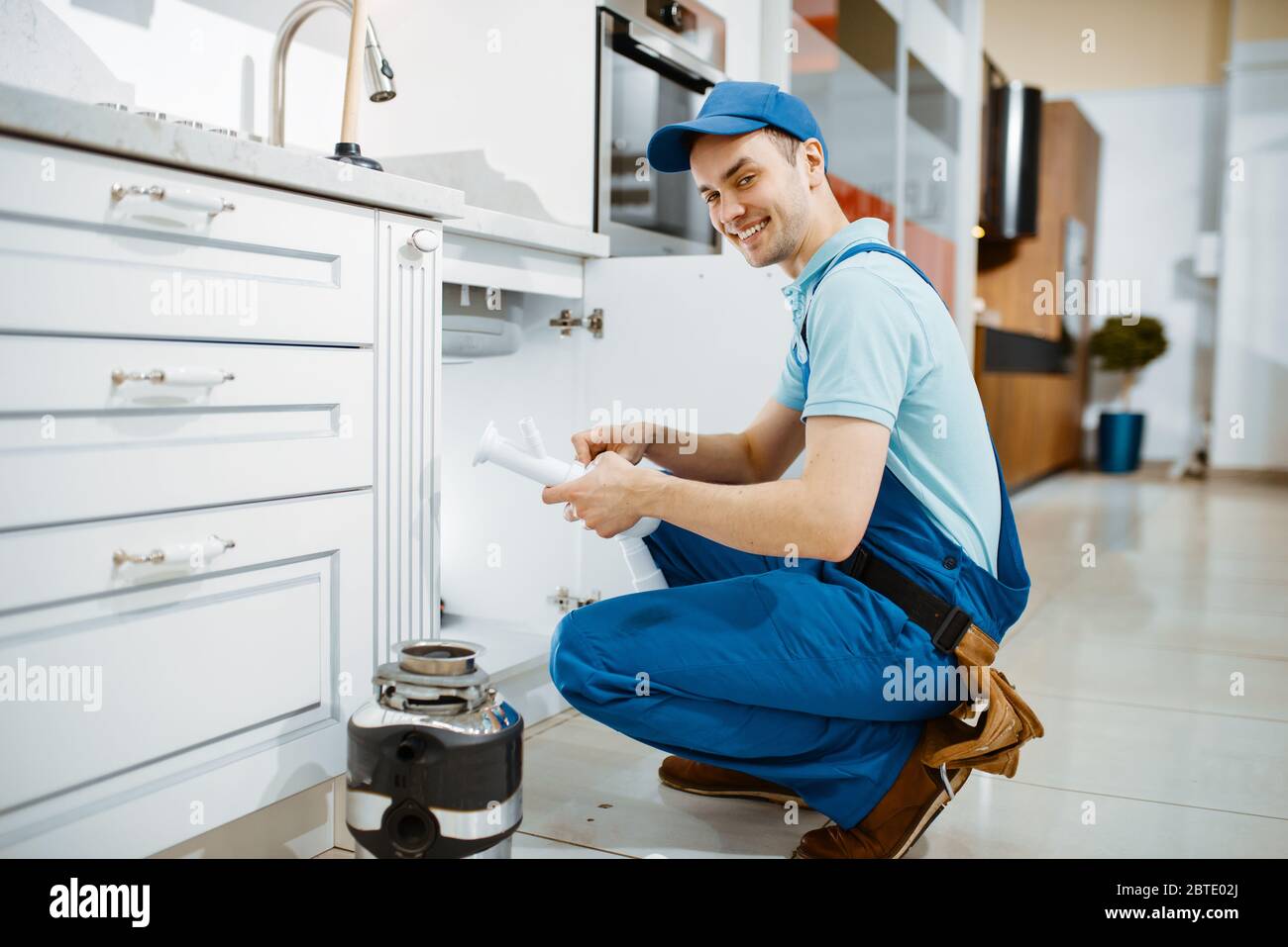 Handsome smiling plumber at the kitchen hi-res stock photography and ...