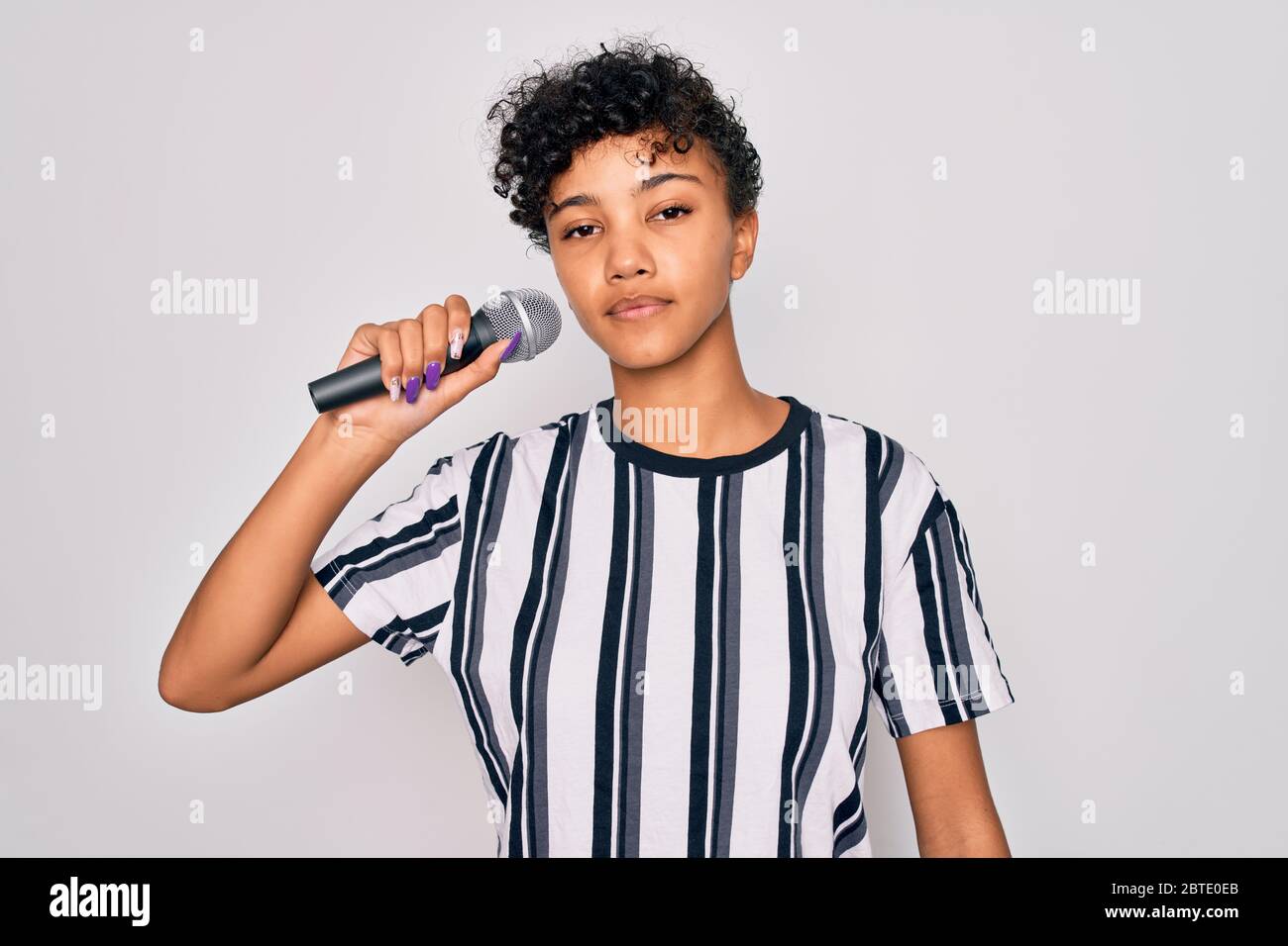 Beautiful african american afro singer woman singing using microphone ...