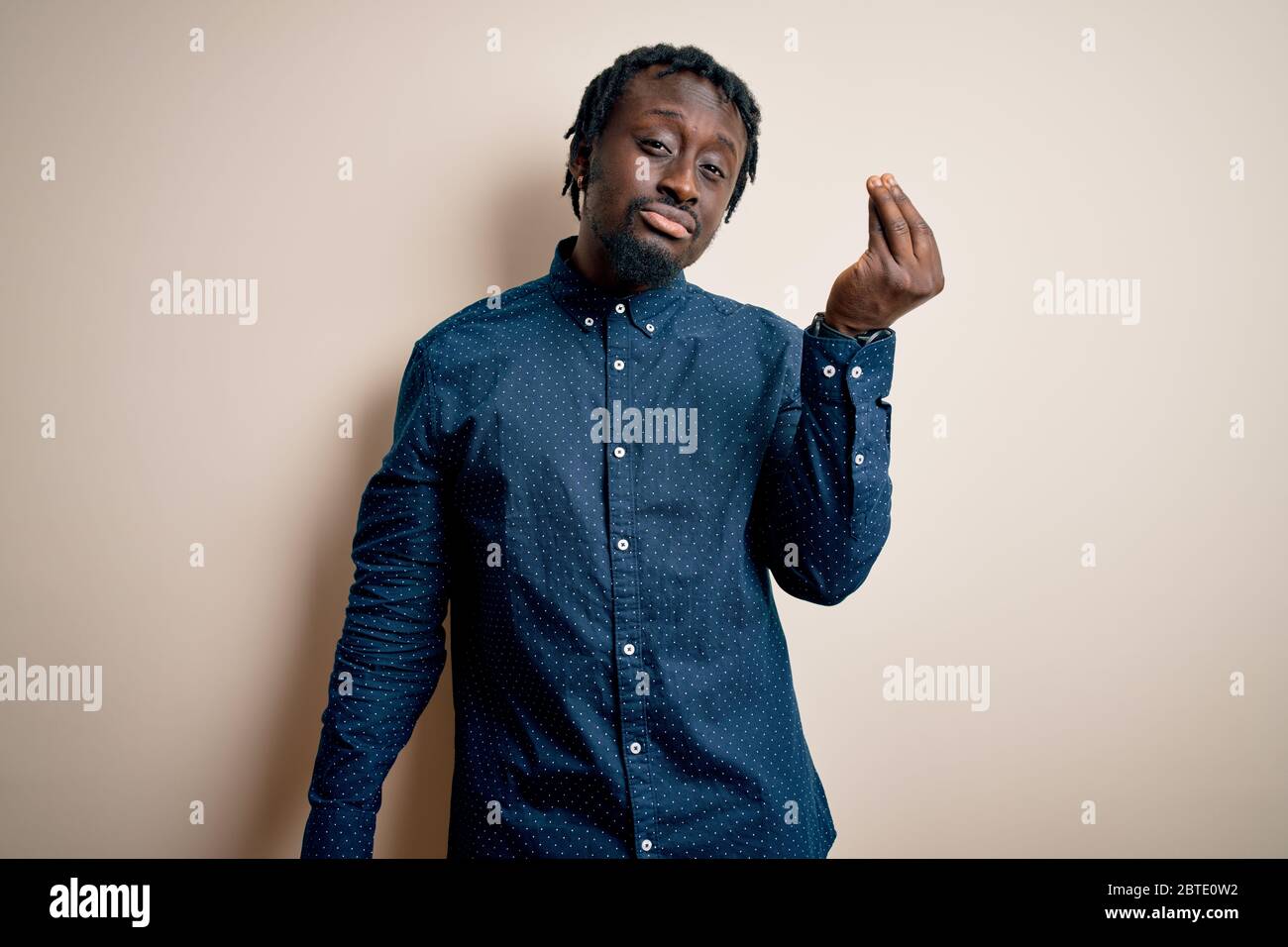 Young handsome african american man wearing casual shirt standing over ...