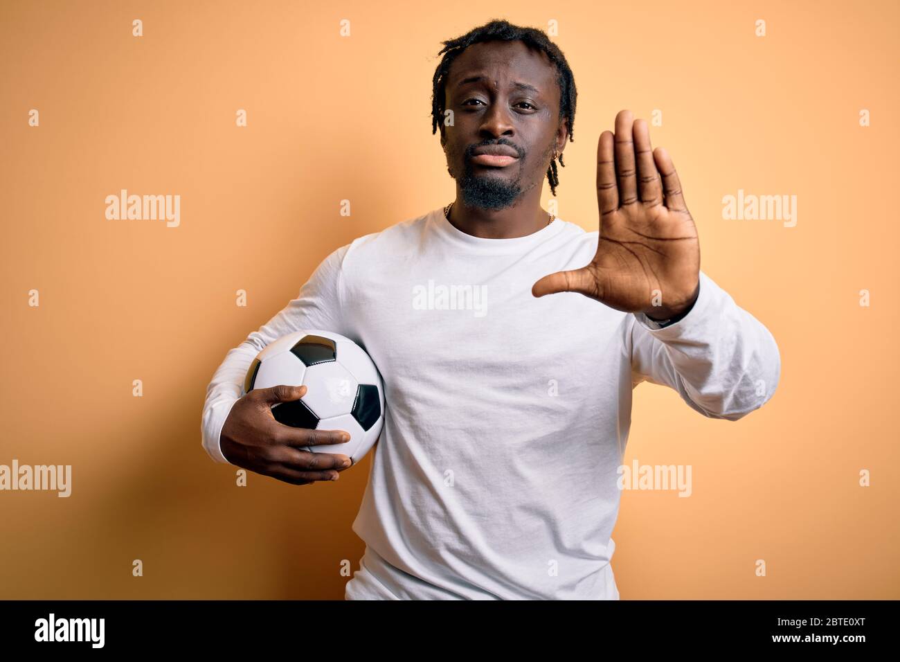 Young african american player man playing soccer holding football ball ...