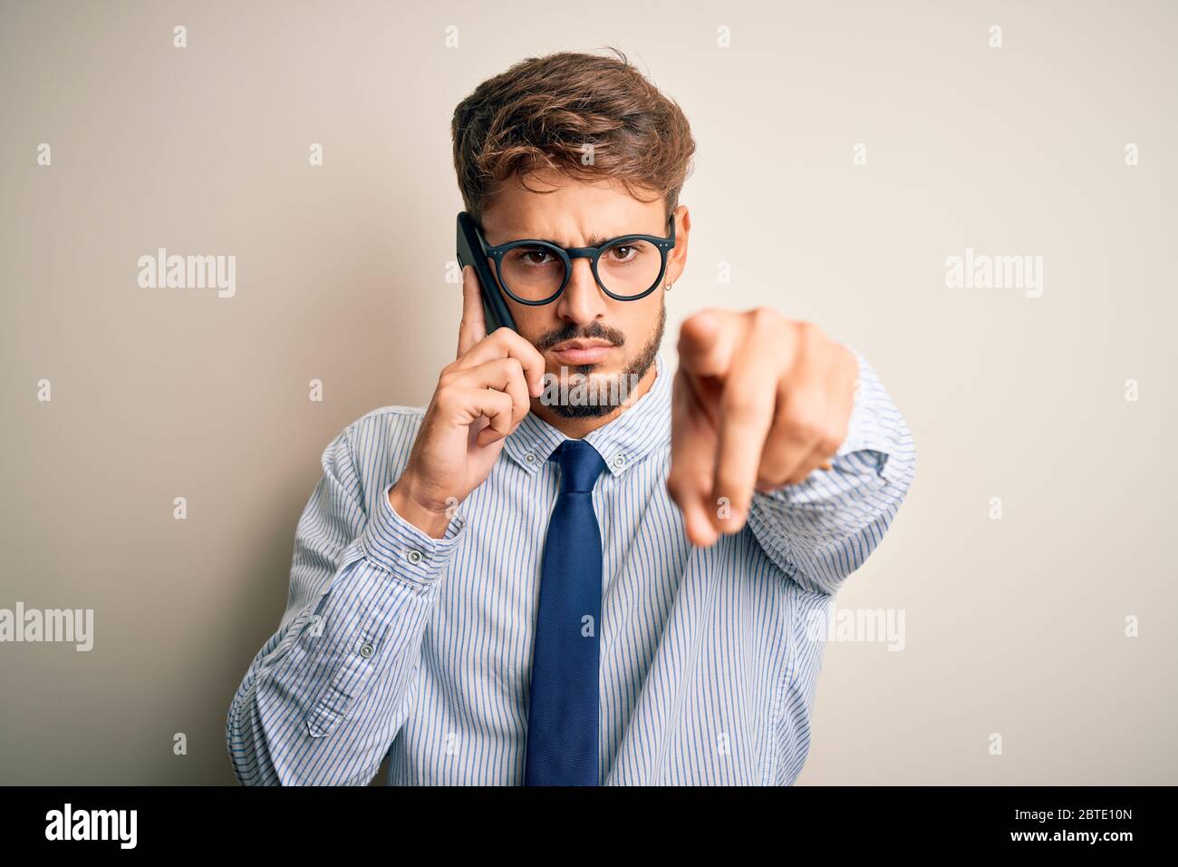 Young businessman having a conversation talking by smartphone over ...