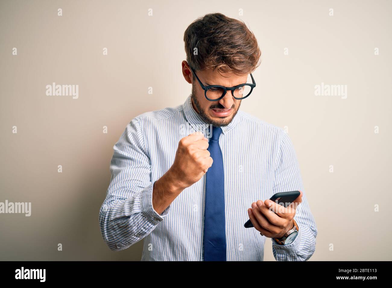 Young businessman having a conversation using smartphone over white ...