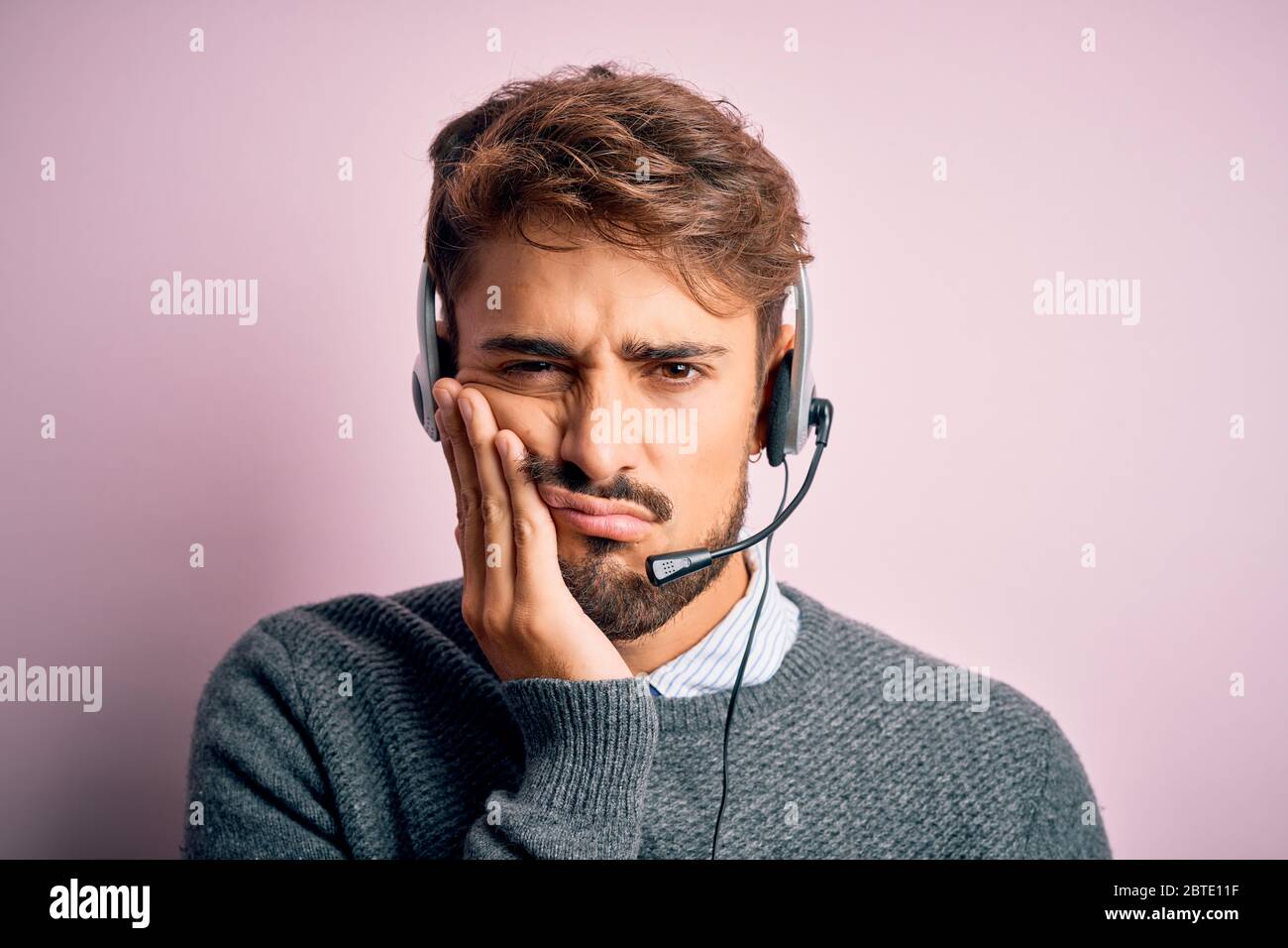 Young call center agent man with beard wearing headset over isolated ...