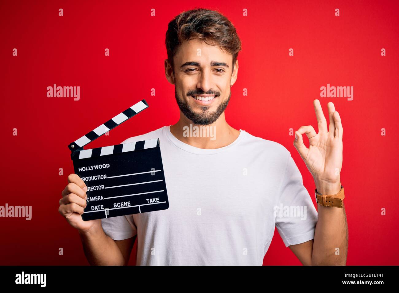 Young director man with beard making movie using clapboard over ...