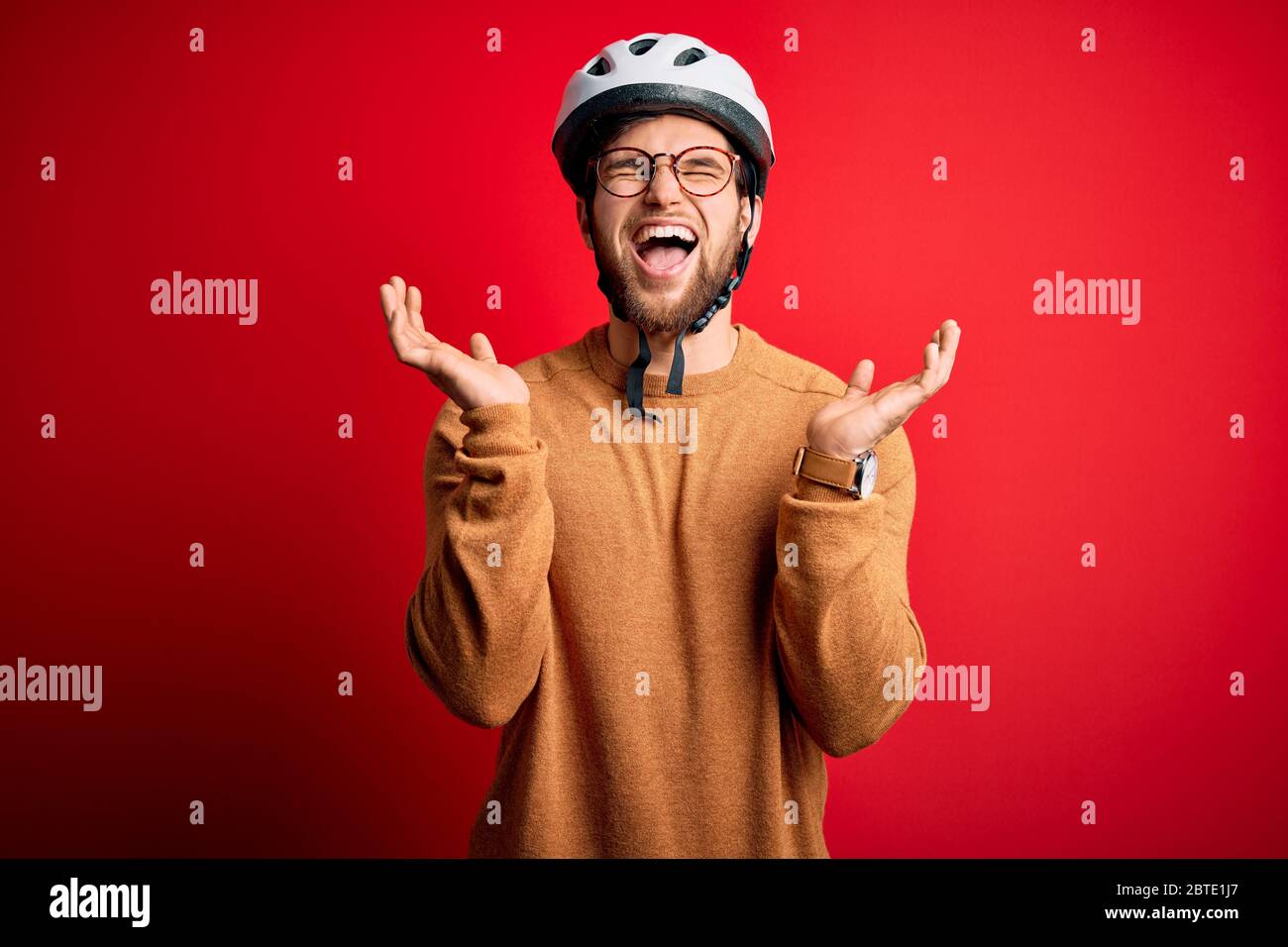 Young blond cyclist man with beard and blue eyes wearing bike helmet ...