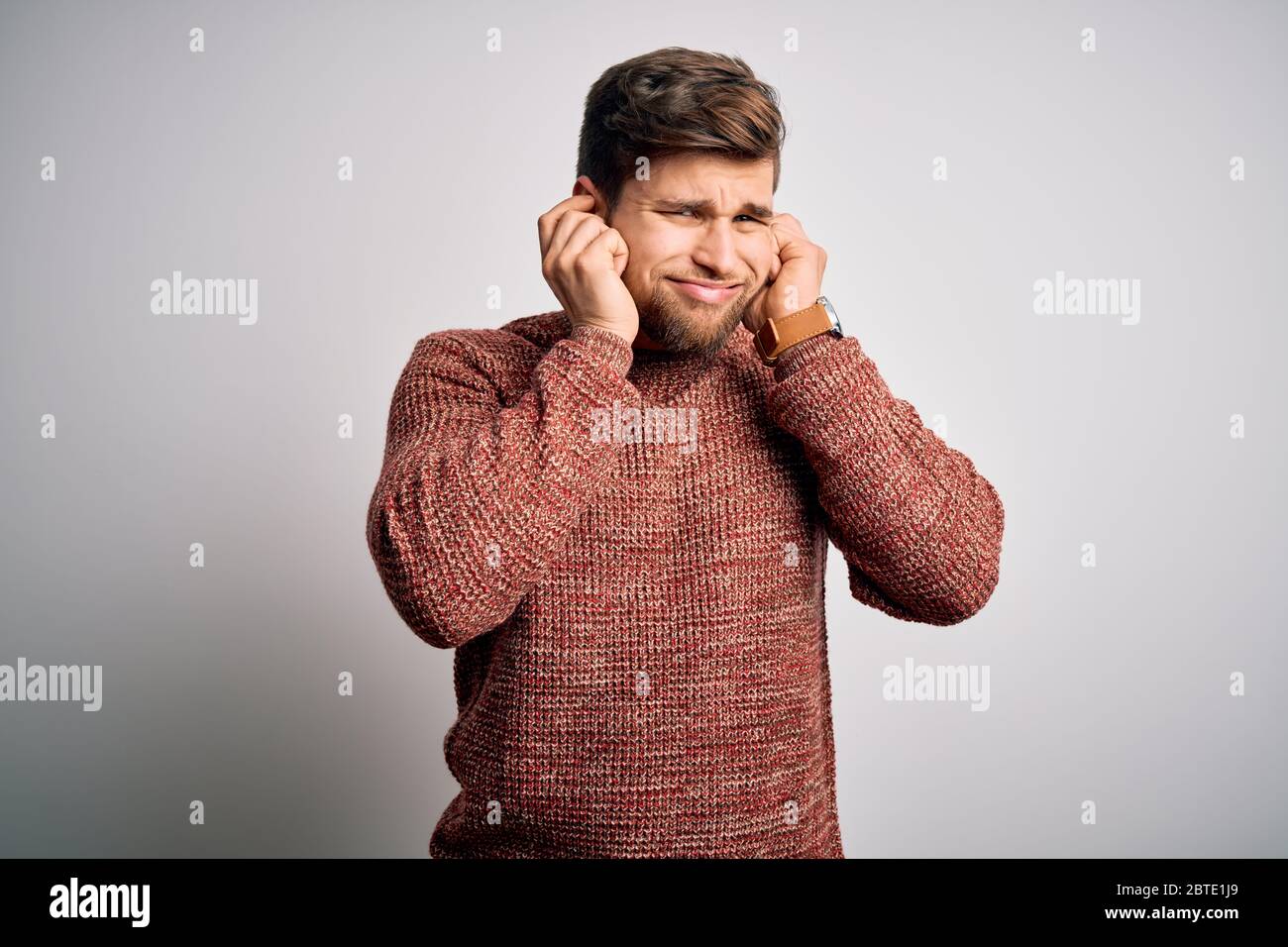 Young blond man with beard and blue eyes wearing casual sweater over ...