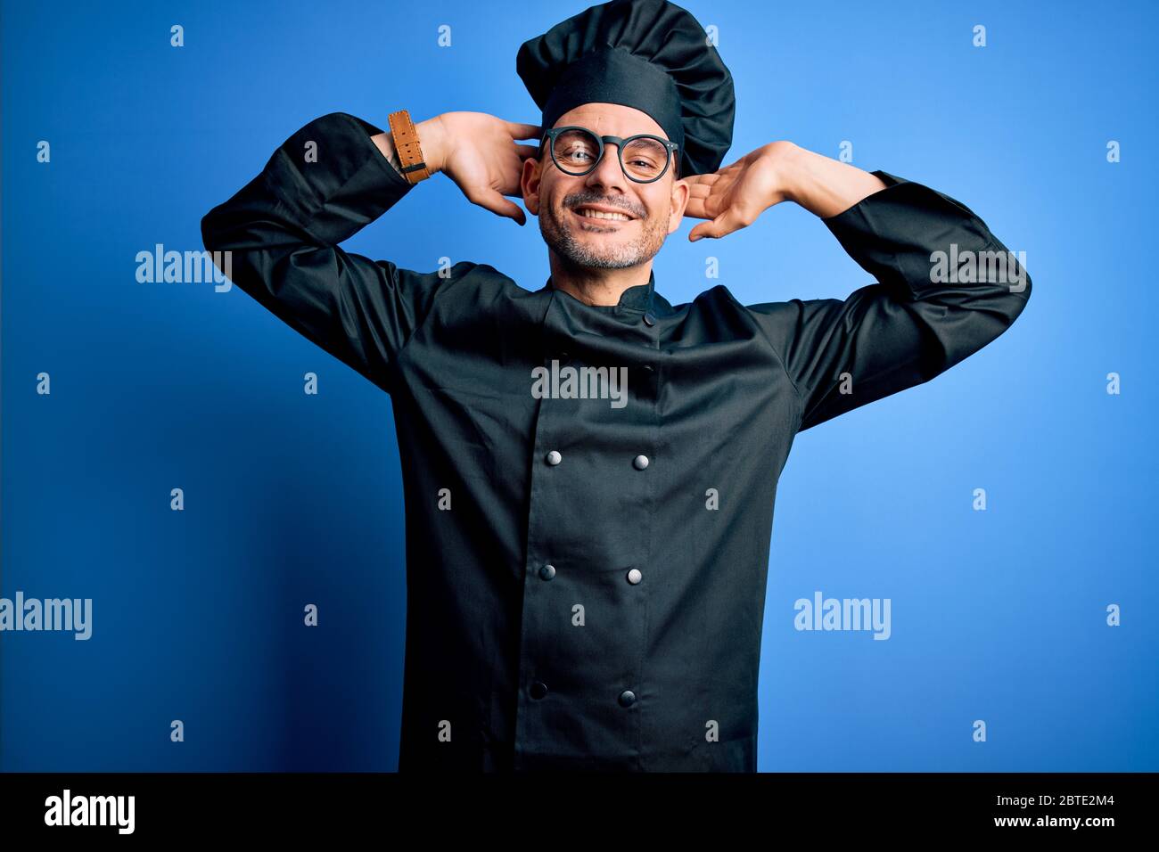 Young handsome chef man wearing cooker uniform and hat over isolated ...