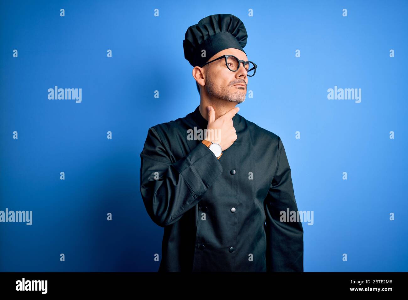 Young handsome chef man wearing cooker uniform and hat over isolated ...