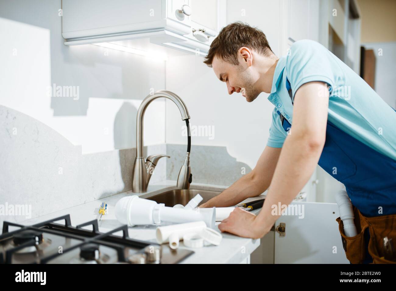 Male plumber fixing sink hi-res stock photography and images - Alamy