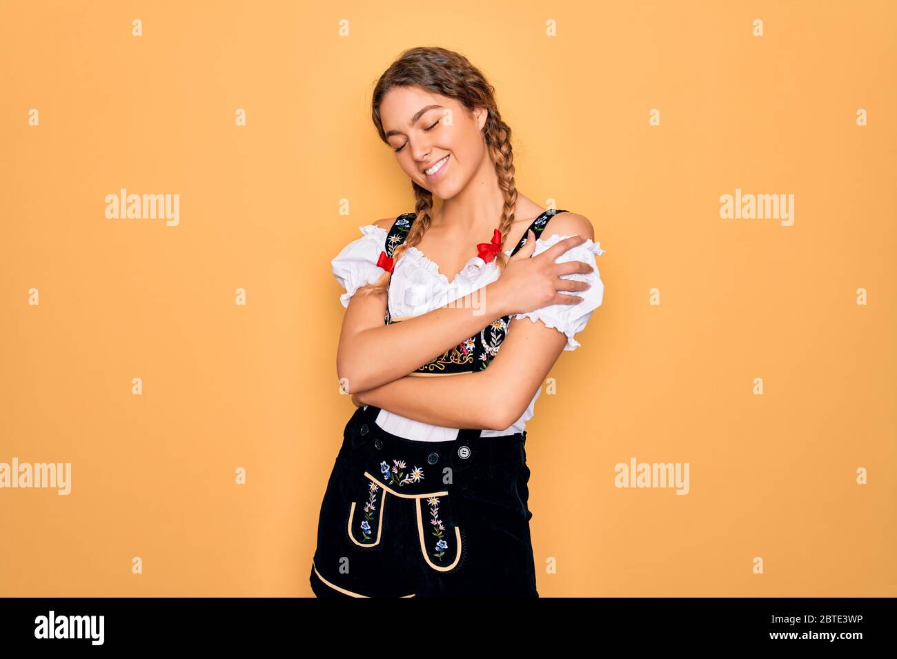 Young beautiful blonde german woman with blue eyes wearing traditional ...