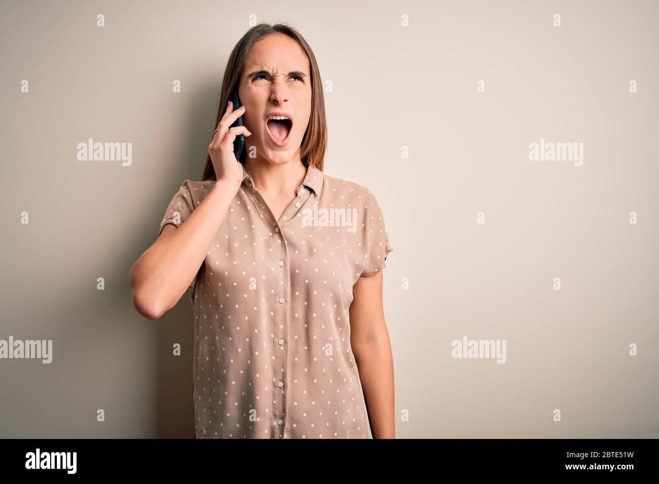 Young beautiful woman having conversation talking on the smartphone ...