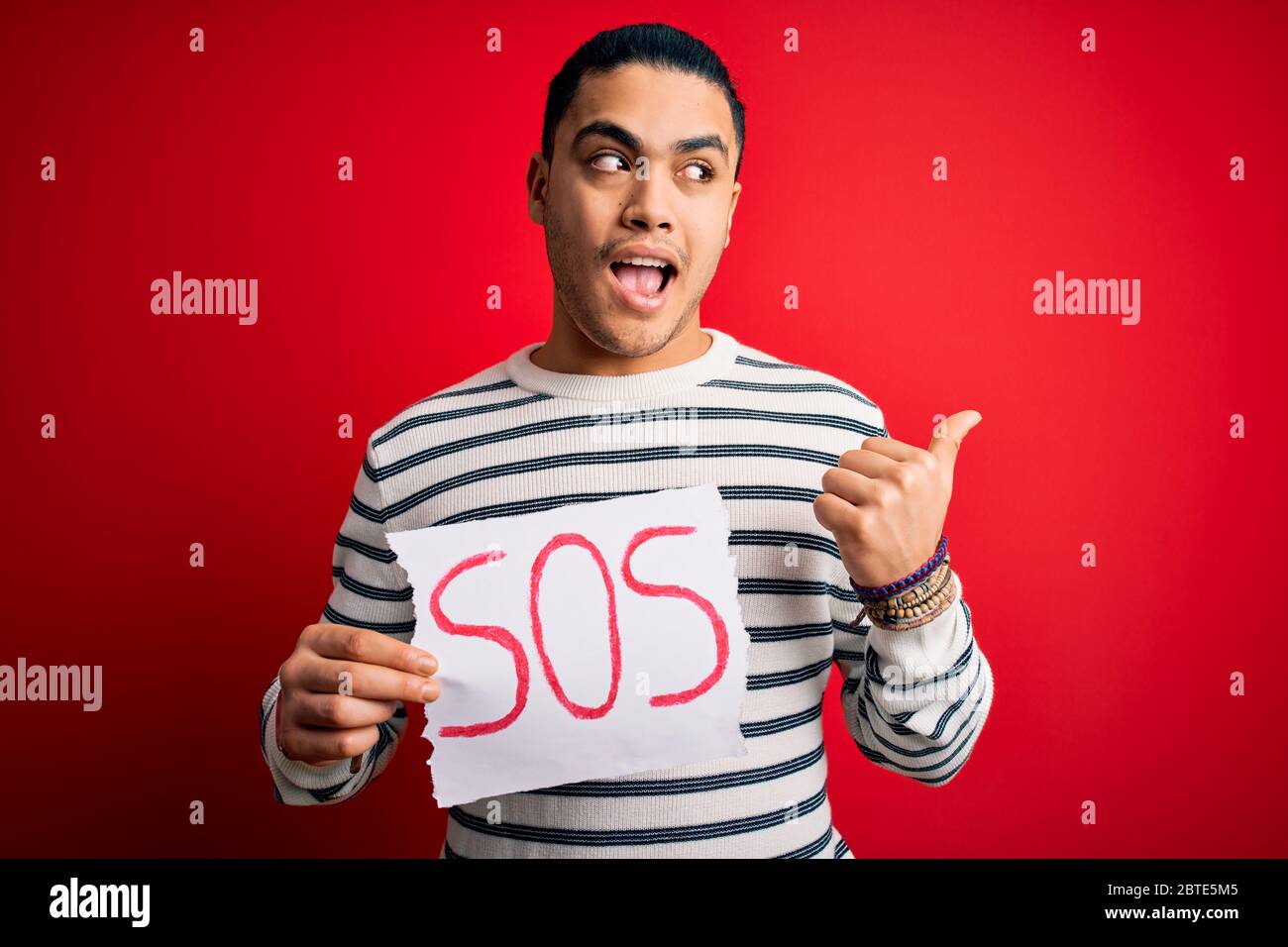 Young brazilian man with problem holding banner with sos message over ...
