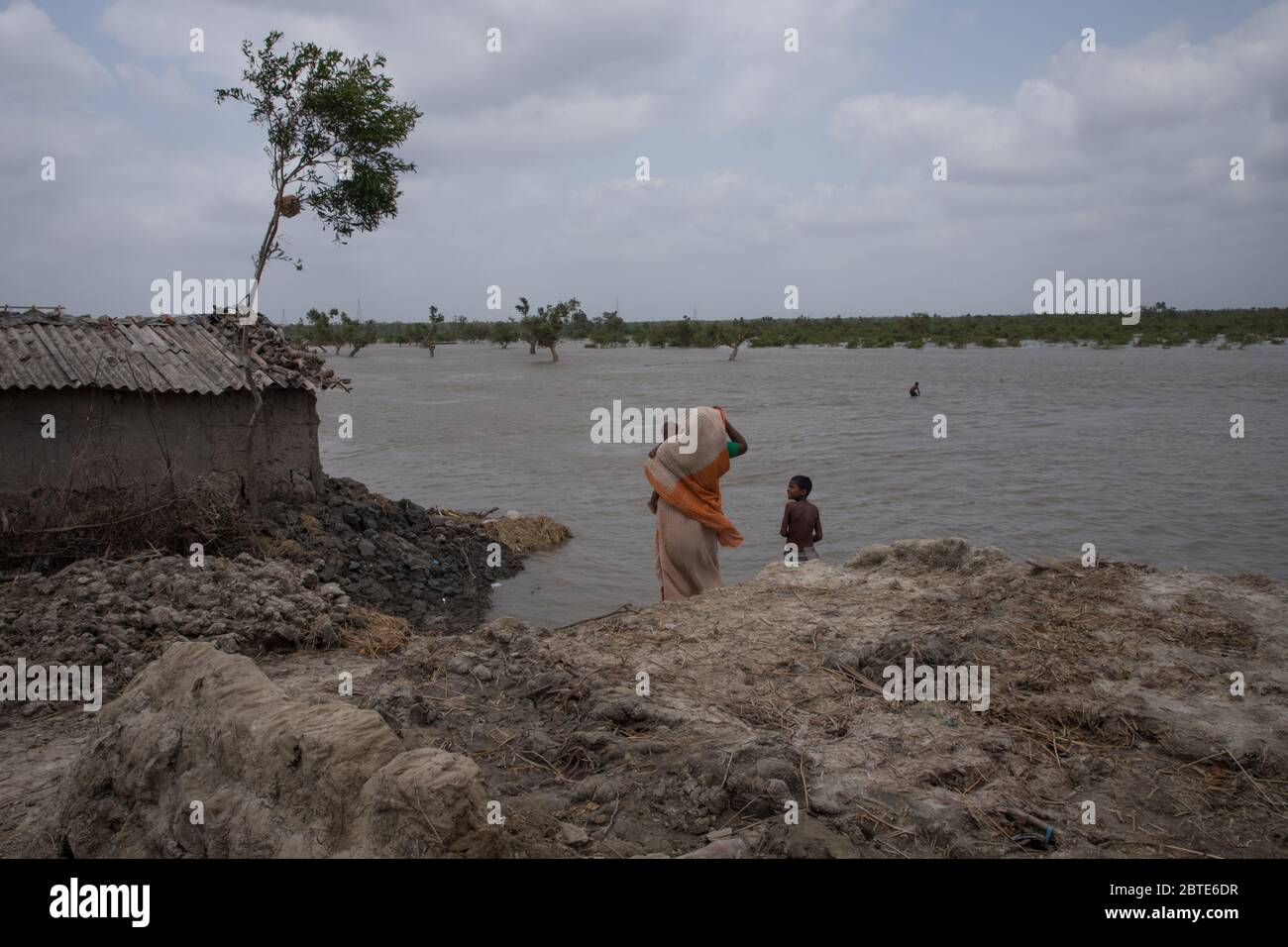 Canning, India. 24th May, 2020. A woman with his 2 children standing ...