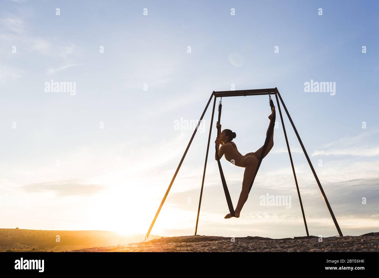 Slim woman practicing fly dance acrobatic yoga poses in hammock ...