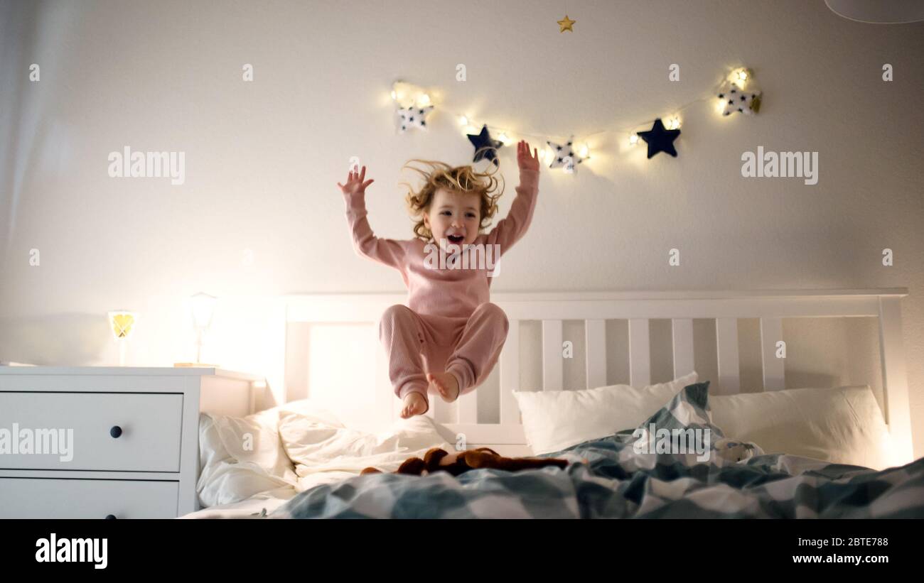 Two small children jumping on bed indoors at home, having fun Stock ...
