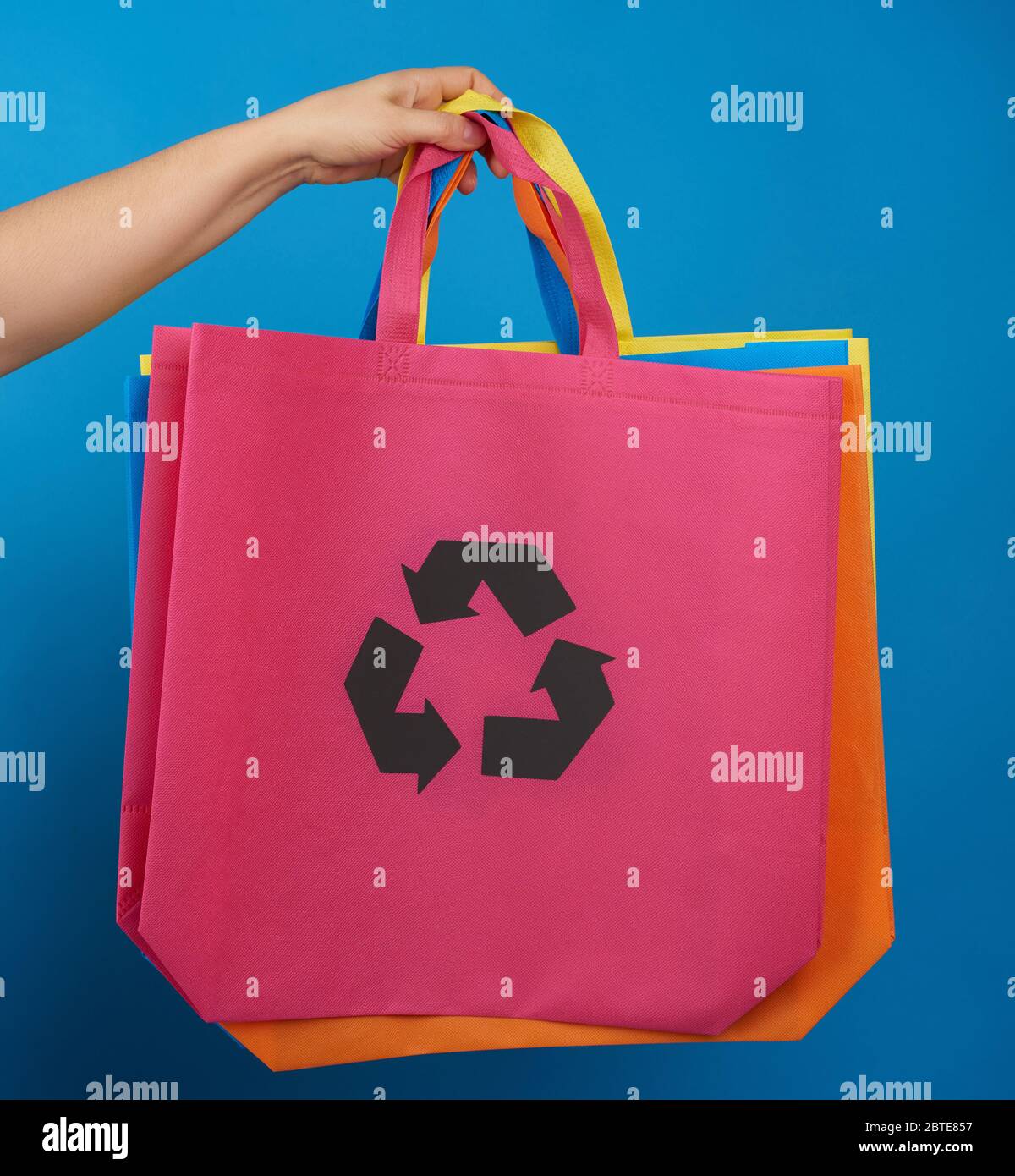 woman's hand holds a pink viscose ecology bag, recyclable material ...