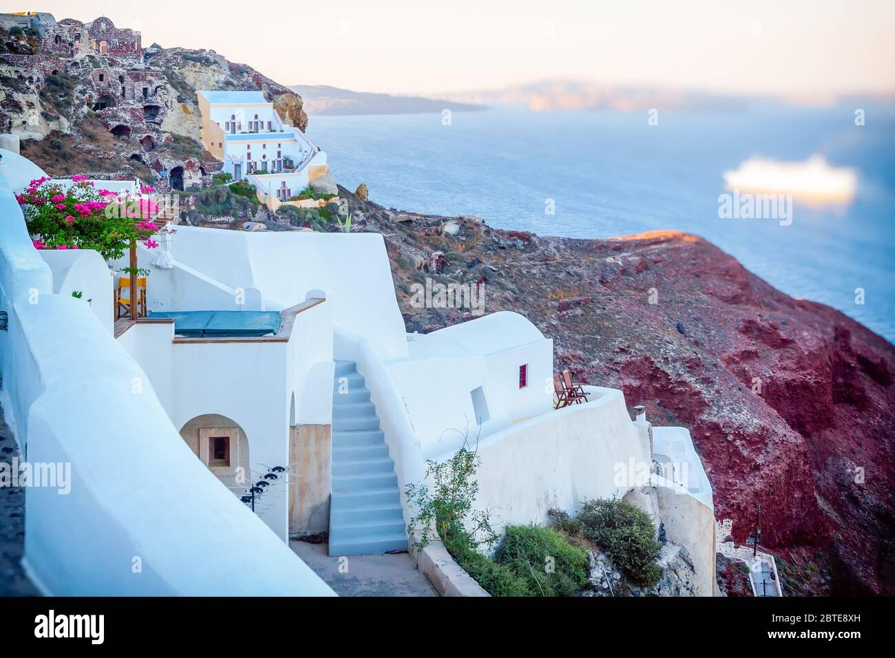 Traditional white cave houses on a cliff on the island Santorini ...