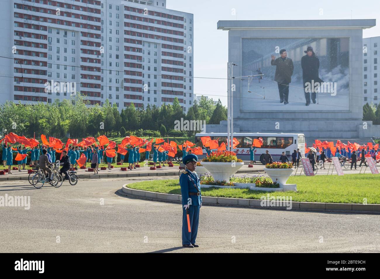 Women wave red flags to encourage people heading to work in Pyongyang ...