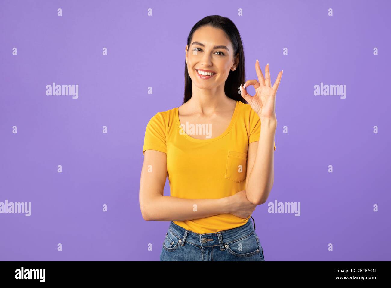 Happy young woman showing ok sign gesture Stock Photo - Alamy