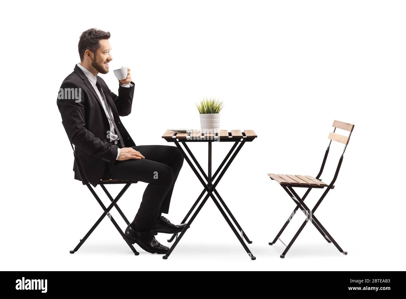 Businessman sitting at a cafe and drinking espresso coffee isolated on ...