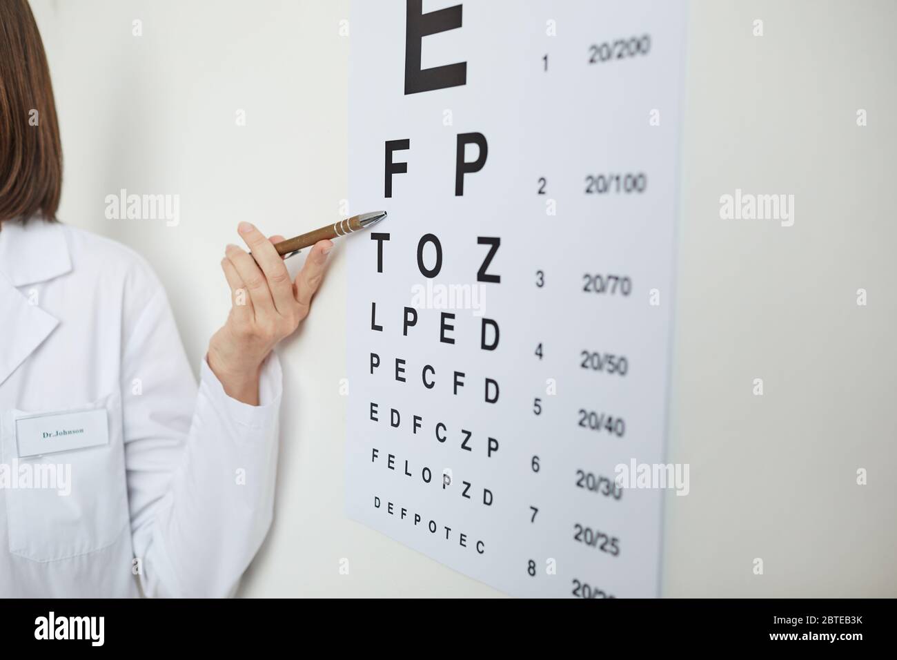 Close up of female hand pointing at eye chart with Latin letters during ...