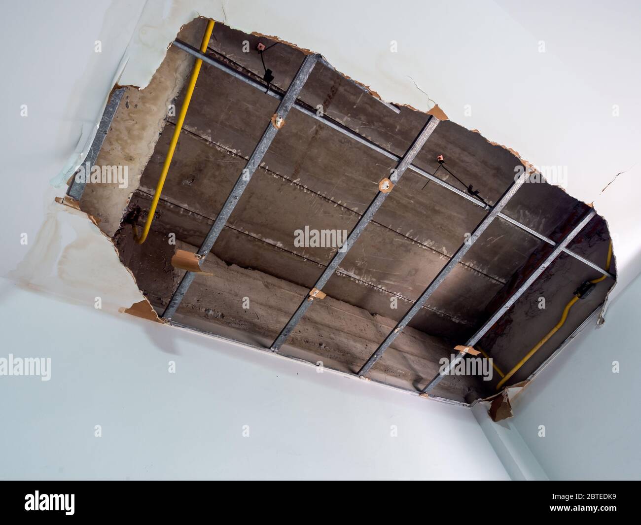 Broken ceiling. Destroyed white ceiling with visible structure inside ...