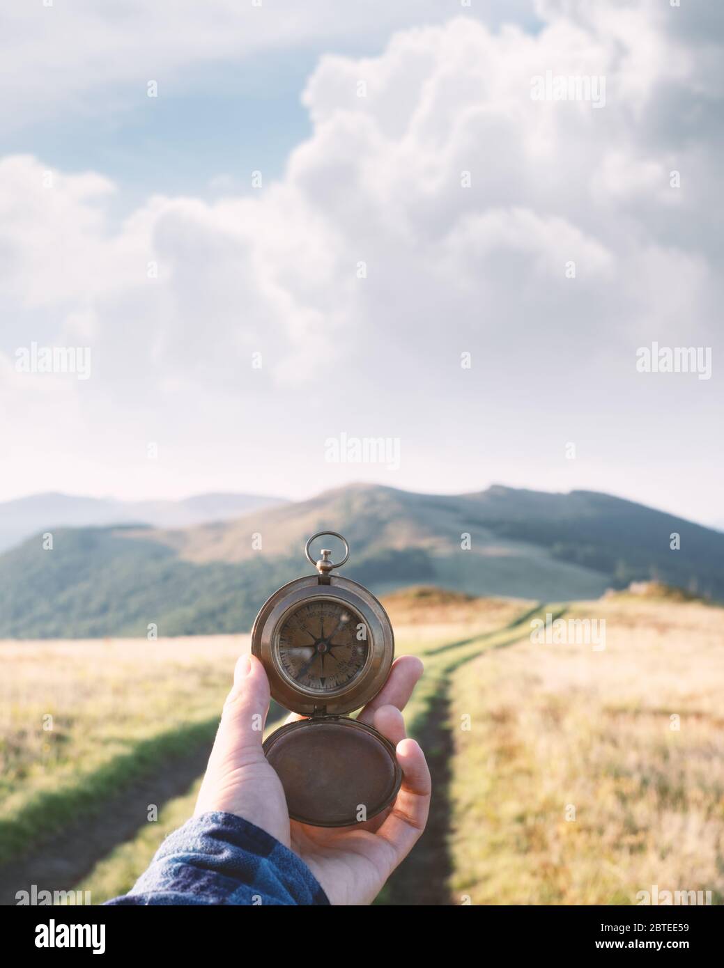 Man with compass in hand on mountains road. Travel concept. Landscape ...