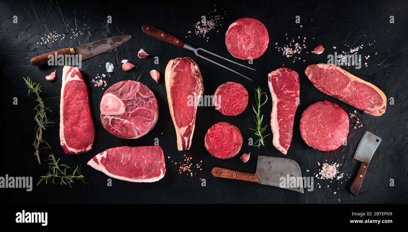 Cuts of meat panorama, shot from the top on a black background with ...