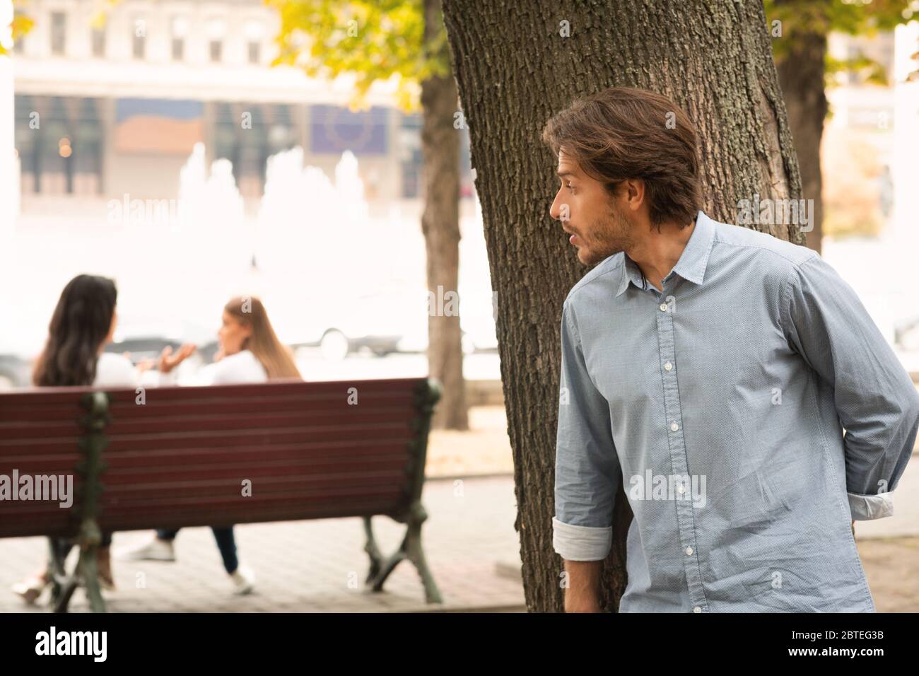 Man Spying On Girls While They Talking Sitting In Park Stock Photo - Alamy