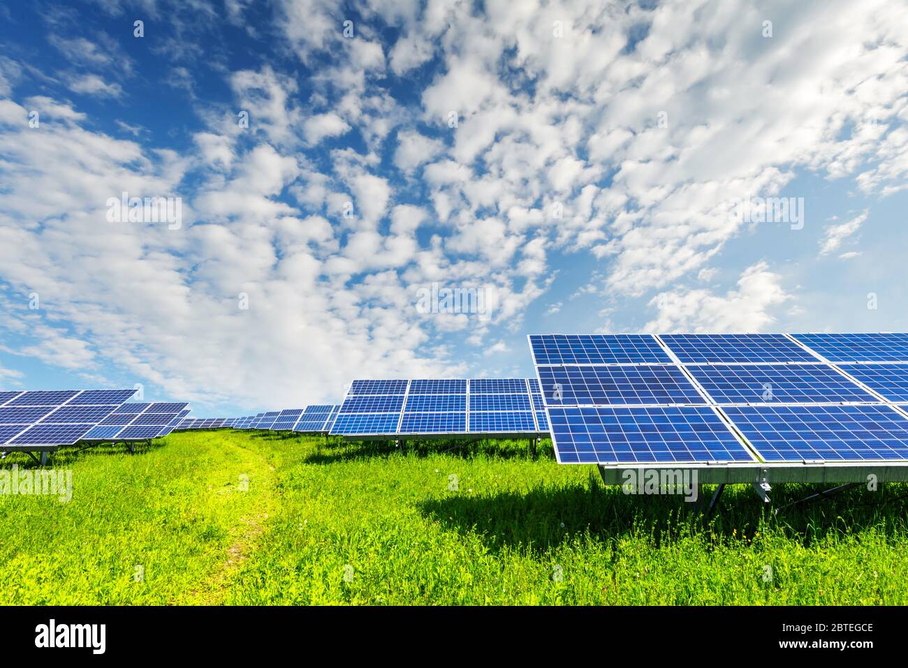Solar panel on blue sky background. Green grass and cloudy sky ...