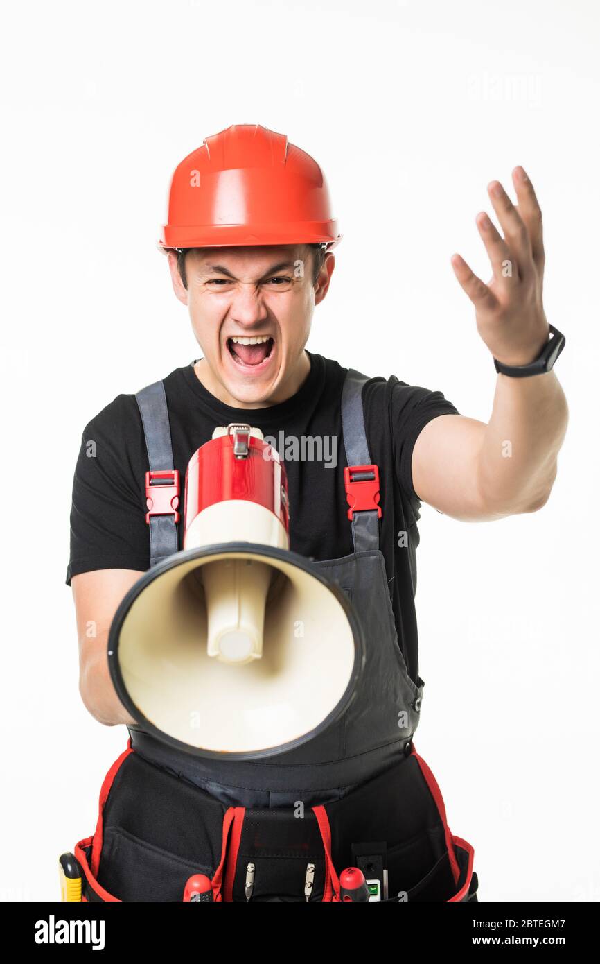 Full length of worker speaking into megaphone over white background ...