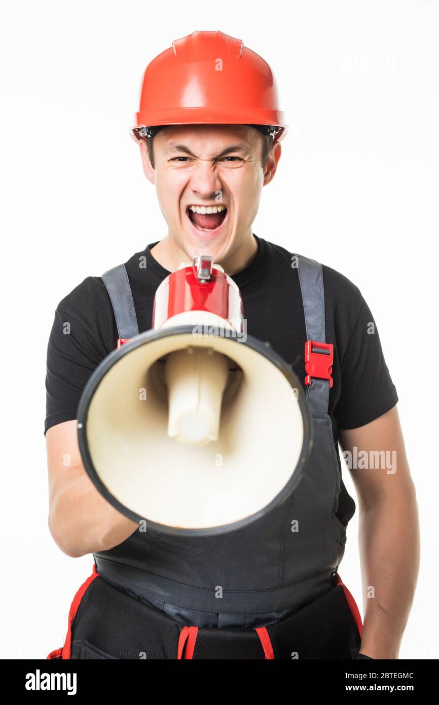 Full length of worker speaking into megaphone over white background ...