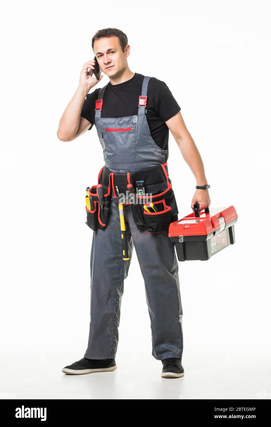 Young repair man talk phone with tools belt and box on white background ...