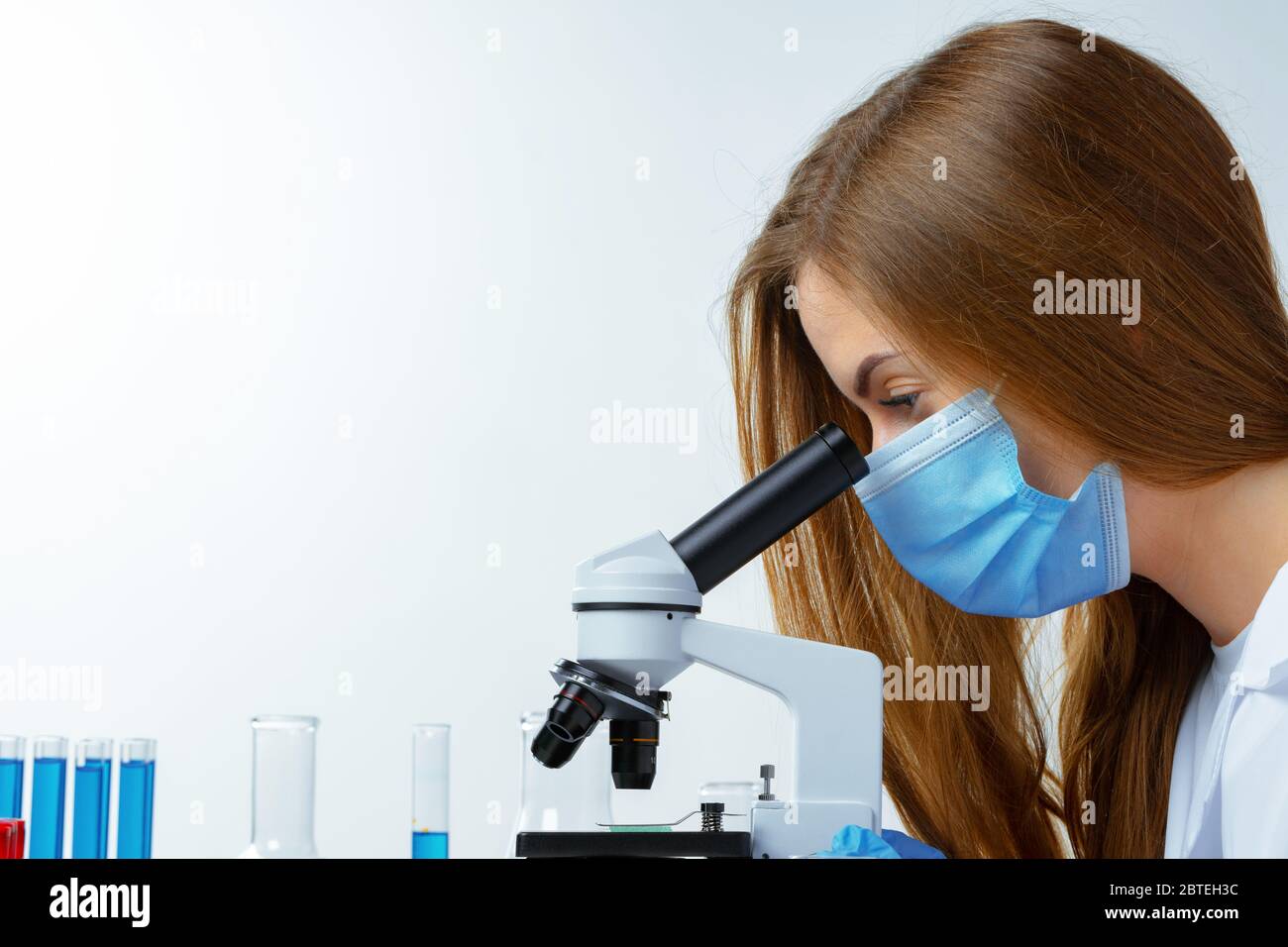 Woman scientist looking through a microscope in laboratory Stock Photo ...