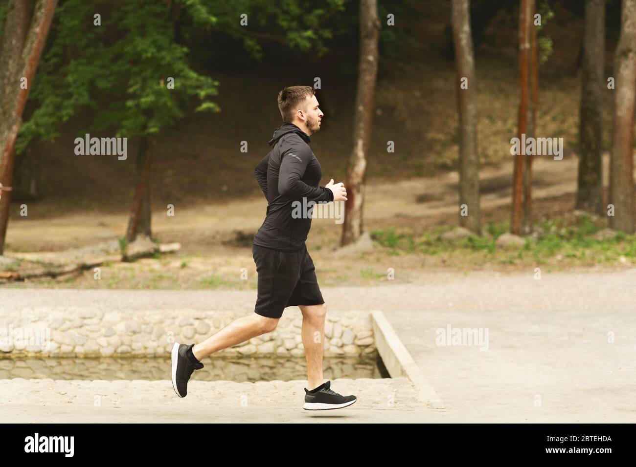 Sporty man running in forest hi-res stock photography and images - Alamy